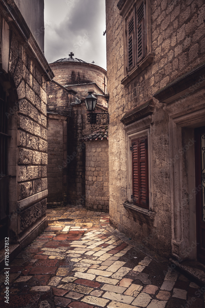 Vintage medieval narrow winding street with ancient stone pavers with ...
