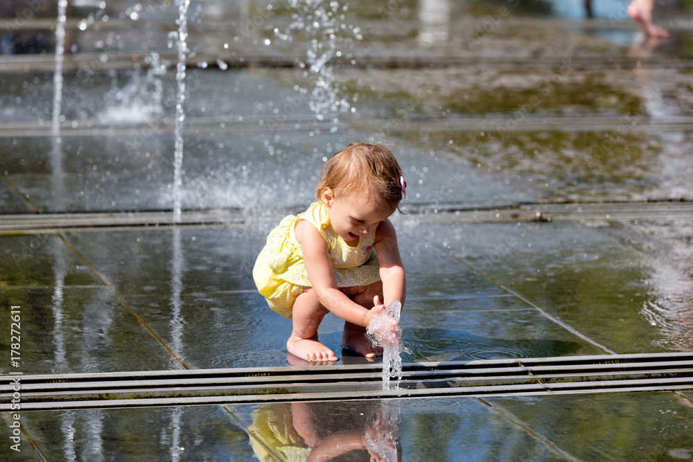 Cute little girl playing with water jets of fountain Stock Photo ...