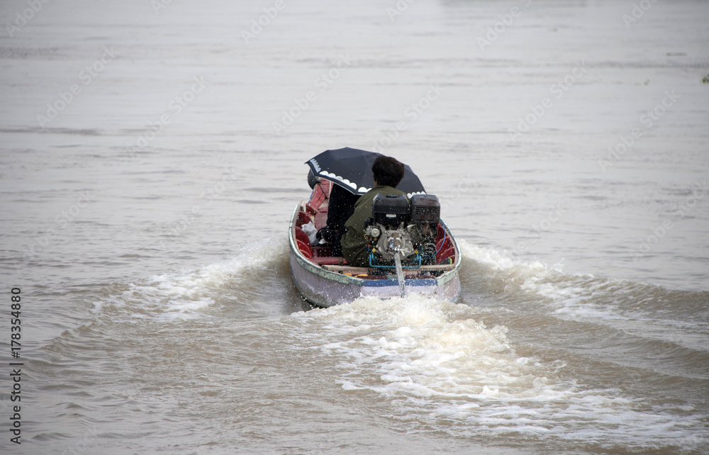 Wooden boat machine driving on the water in the river. it is a small ...