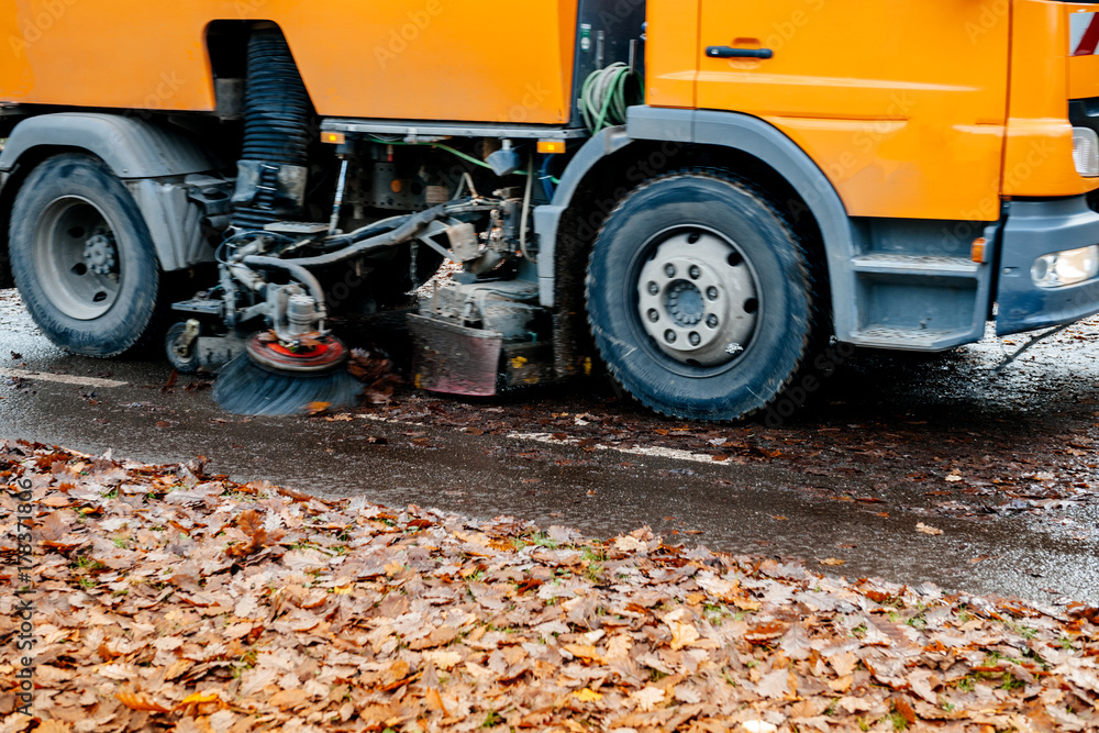 Modern street management with orange street sweeper truck on the street ...