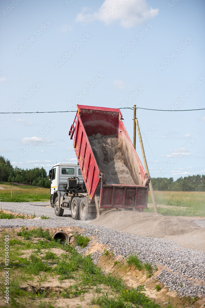 Dump truck is unloading soil. Dumper truck is unloading soil or sand at ...