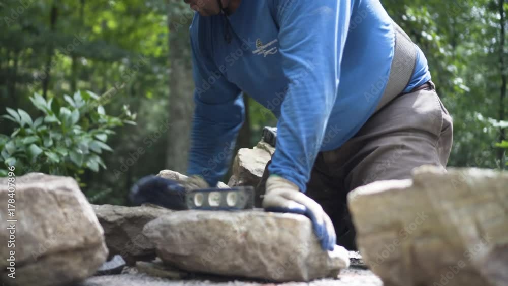 Hardscape uses a rock shim to check and change the level of a large ...