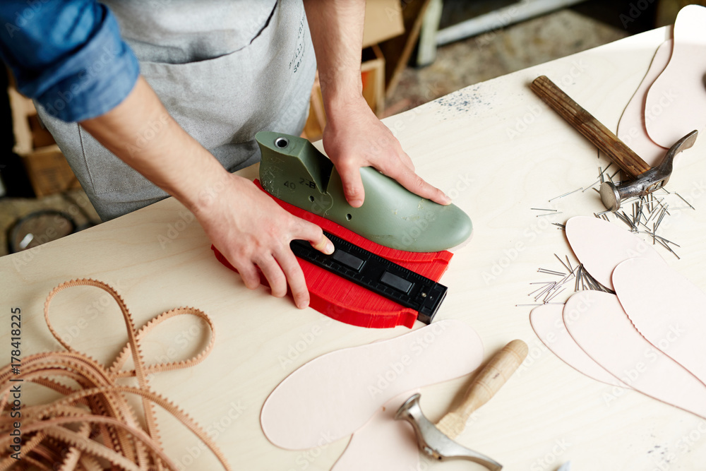 Master of own cobbler workshop doing his work by large table Stock ...