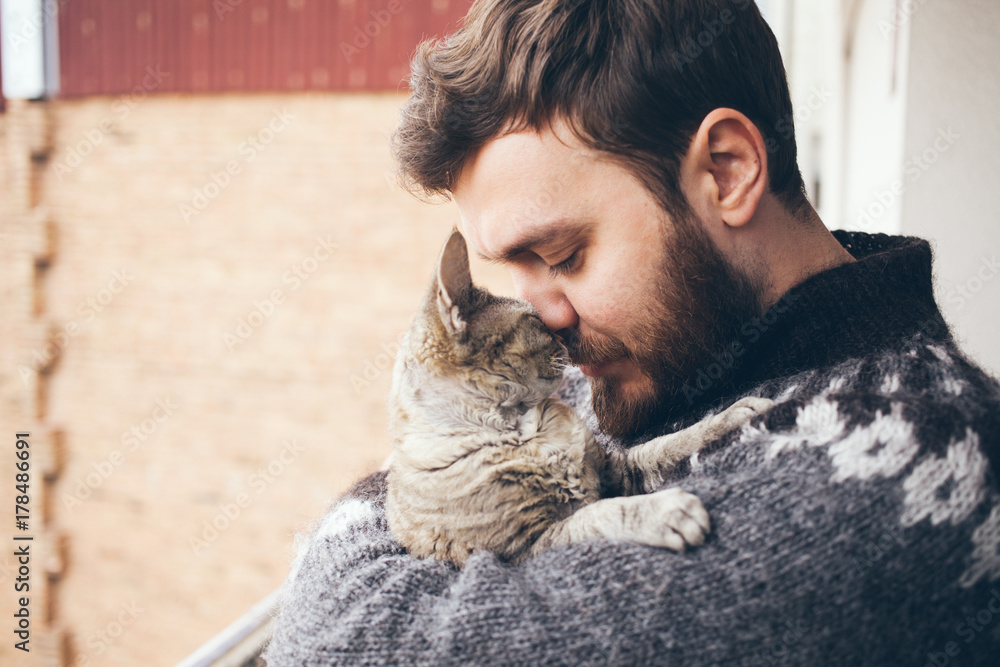 Cat and man, portrait of happy cat with close eyes and young man ...