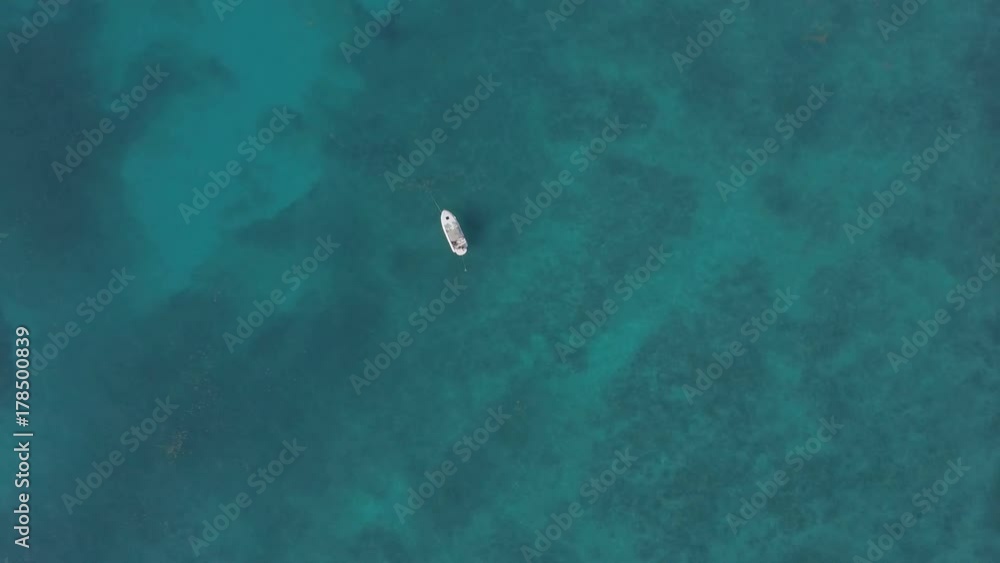 Drone looking straight down at a boat anchored in the middle of the ...