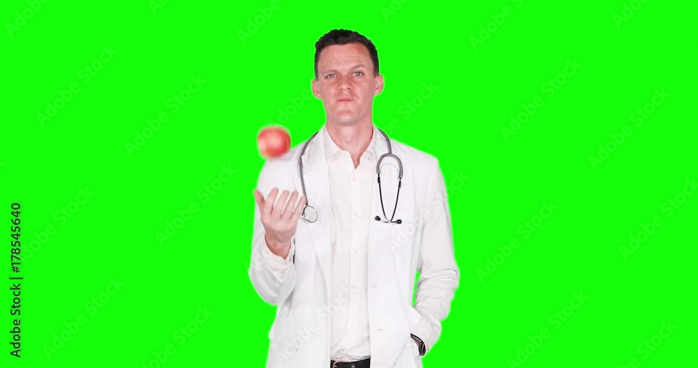 Handsome Caucasian doctor throwing a red apple in the studio, shot in ...