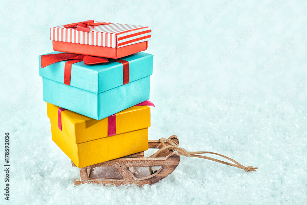 Sledge on snow with presents. Red, blue and yellow Christmas gift boxes ...