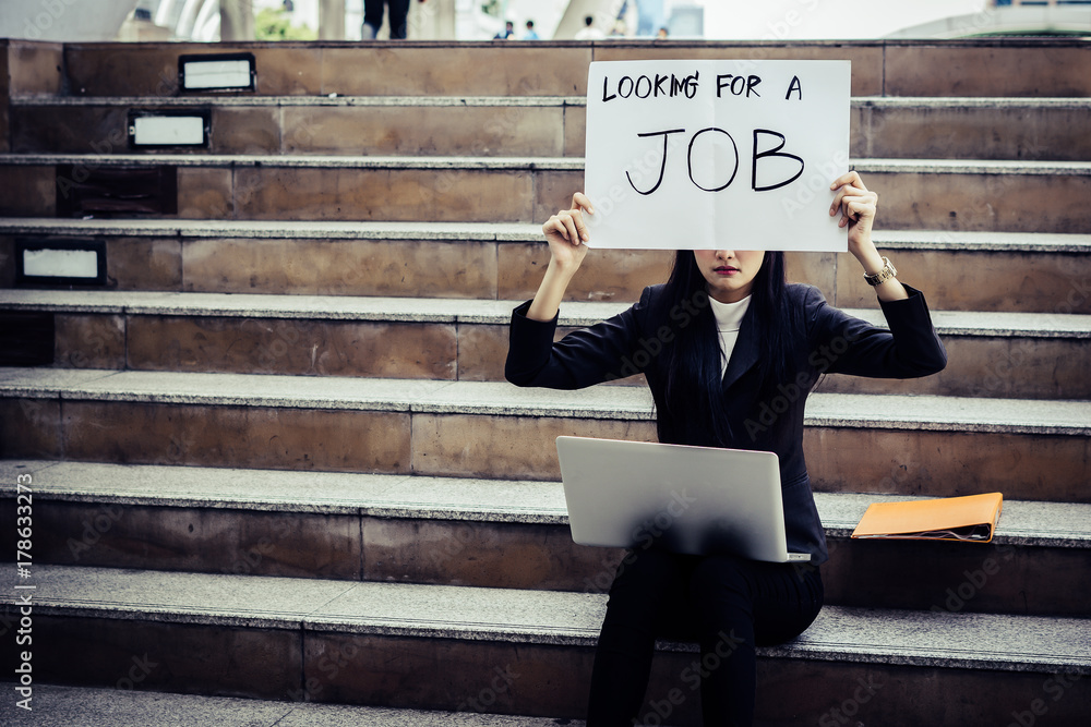 Unemployed woman desperately looking for a job. Holding a need a job ...