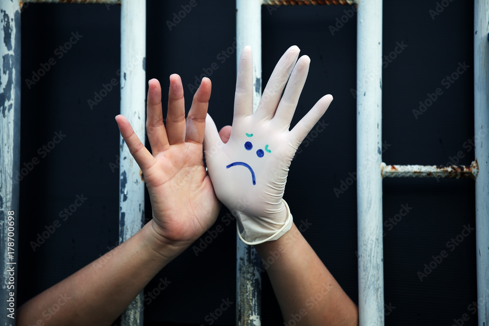 emojicon "sad" face on hand of prisoner in jail Stock Photo | Adobe Stock