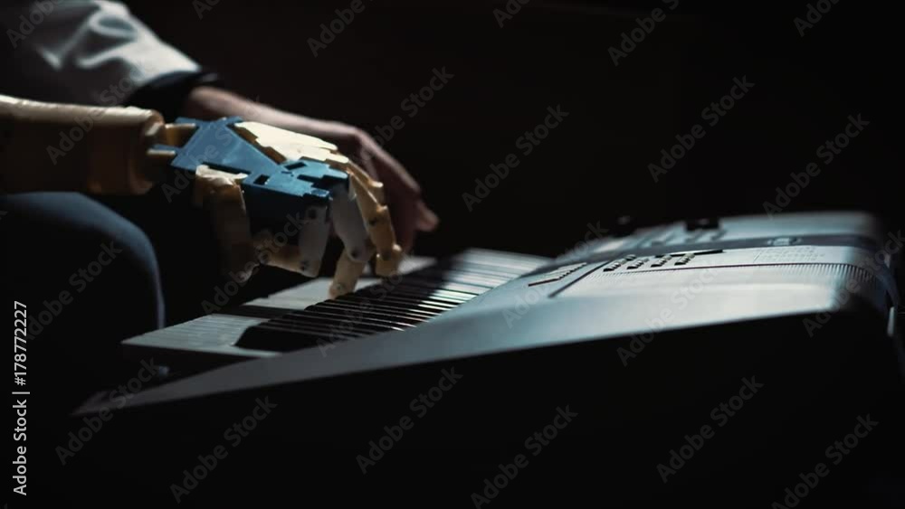 man musician pianist with a prosthetic hand playing the piano. He plays ...