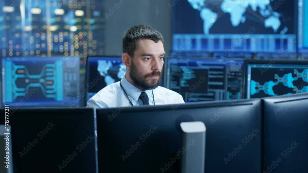 In the System Control Center Operator Working Surrounded by Displays ...