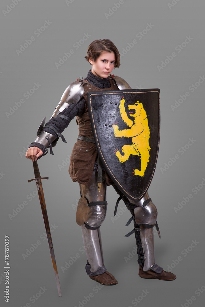 Girl in armor with a sword knight wuth shield over grey background ...