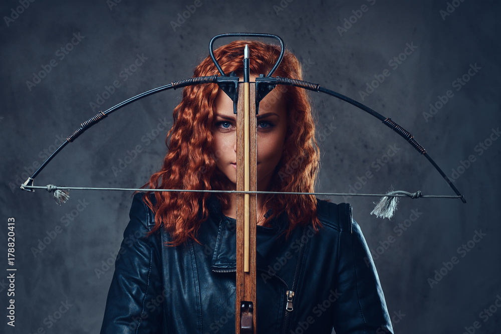 Redhead female holds crossbow. Stock Photo | Adobe Stock