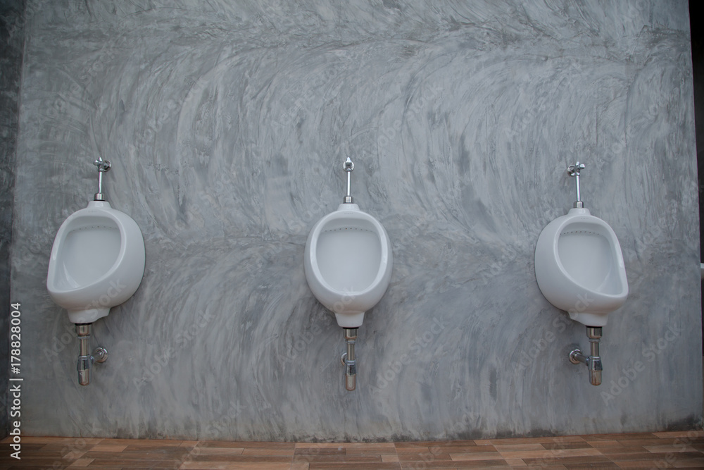 Closeup of three white urinals in men's bathroom design of white ...
