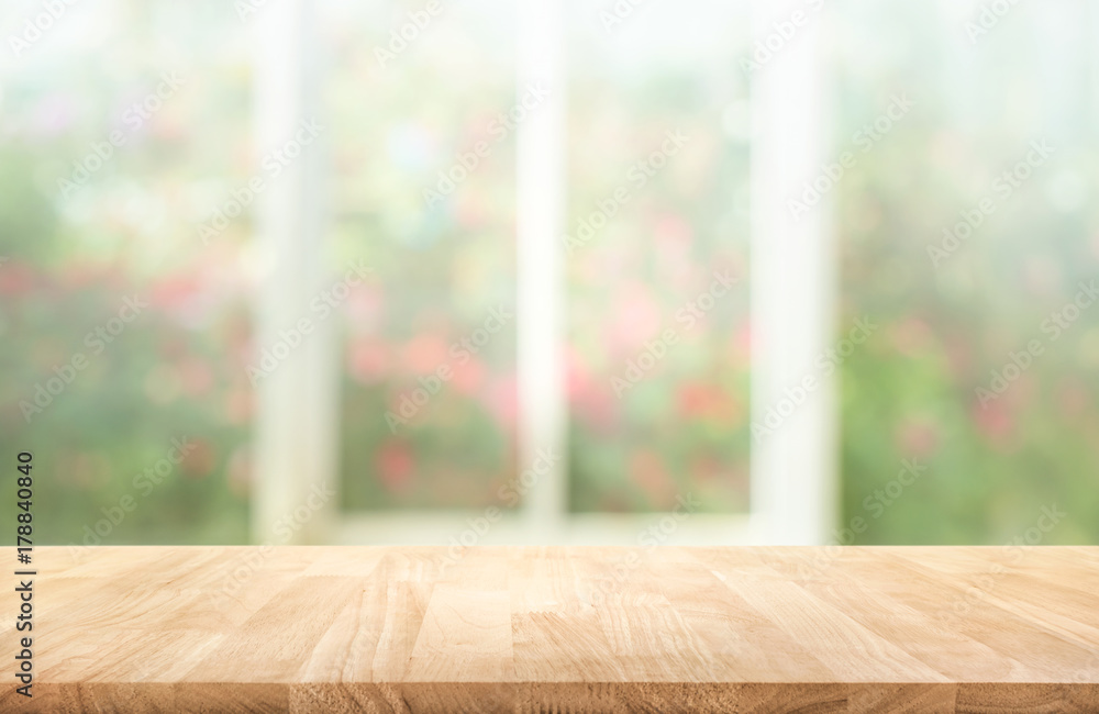 Wood table top on blur of window with garden flower background in ...
