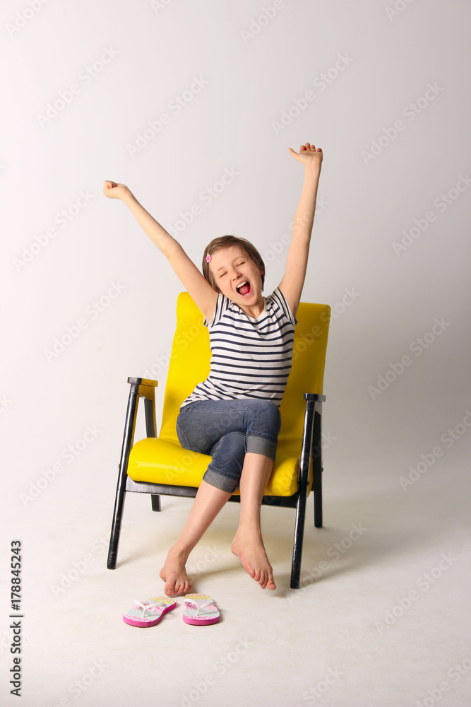 Tired sleepy girl yawning with a stretch while sitting on chair over ...