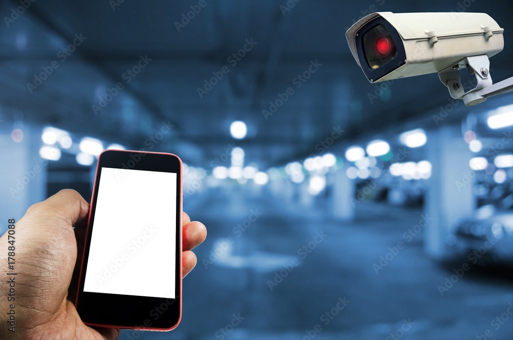 hand using mobile phone with blank screen and CCTV, security indoor ...