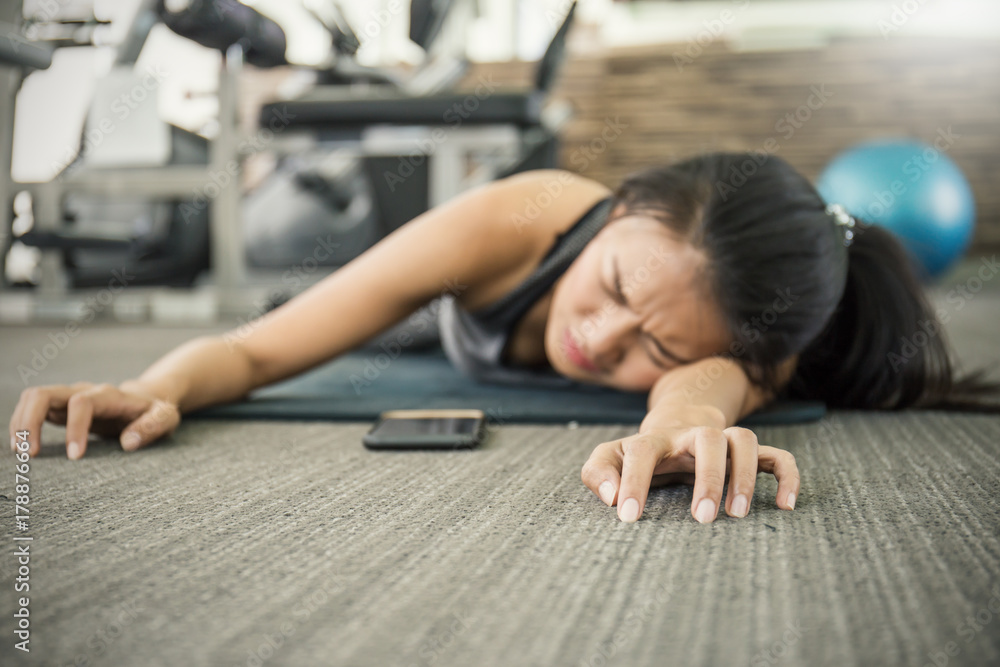 Asian tan woman fainting to the floor during her exercise at the sport ...