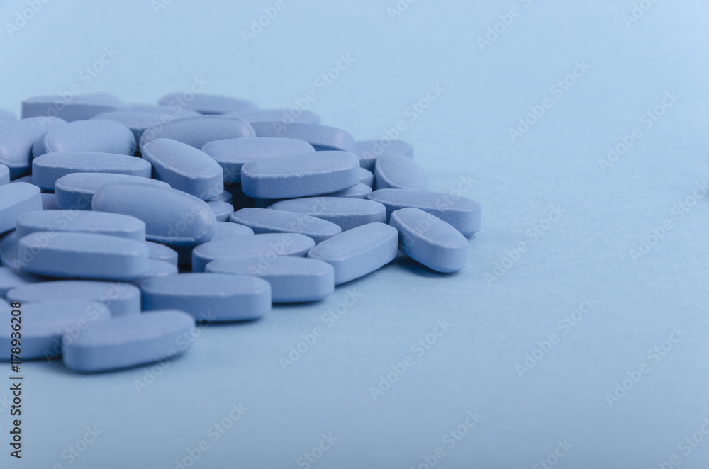 perspective view of blue medical tablets over a light blue background ...
