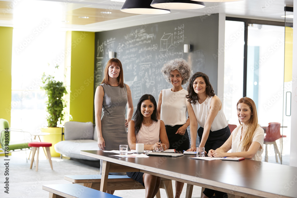 Five female colleagues at a work meeting smiling to camera Stock Photo ...