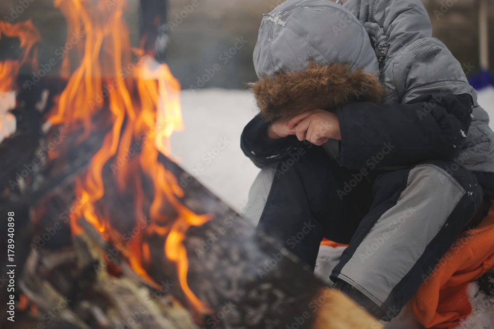 boy sitting by fire in the street Stock Photo | Adobe Stock