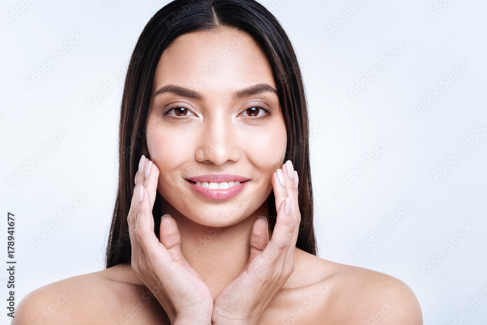 Upbeat dark-haired woman cupping her face in both hands Stock-Foto ...