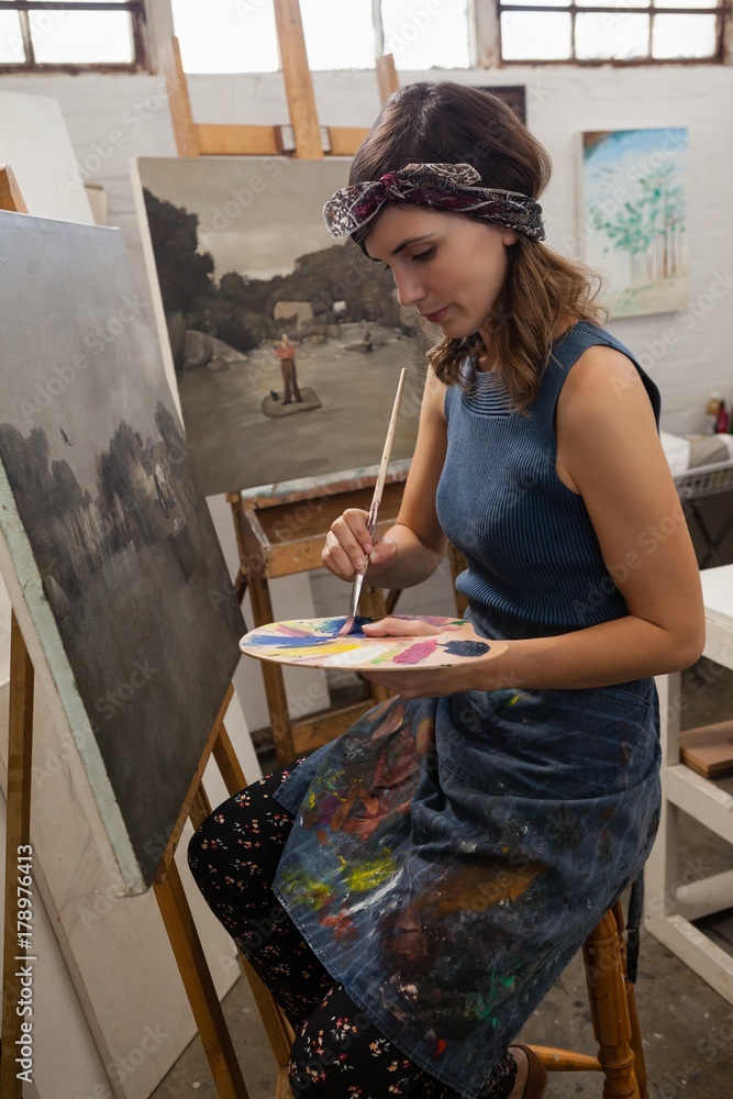 Woman painting on canvas in drawing class Stock Photo | Adobe Stock