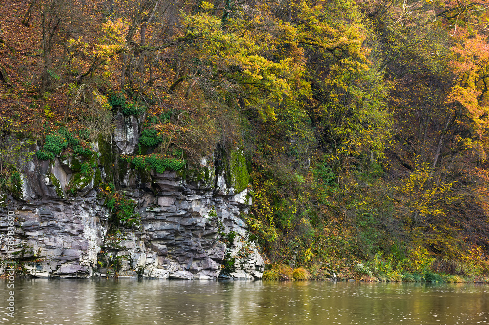 rocky cliff over the river in forest. beautiful autumn background with ...