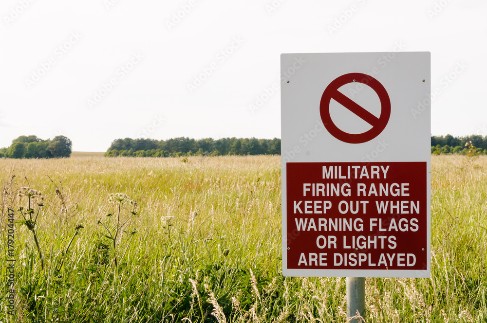 Sign "Military firing range. Keep out when warning flags or lights are ...
