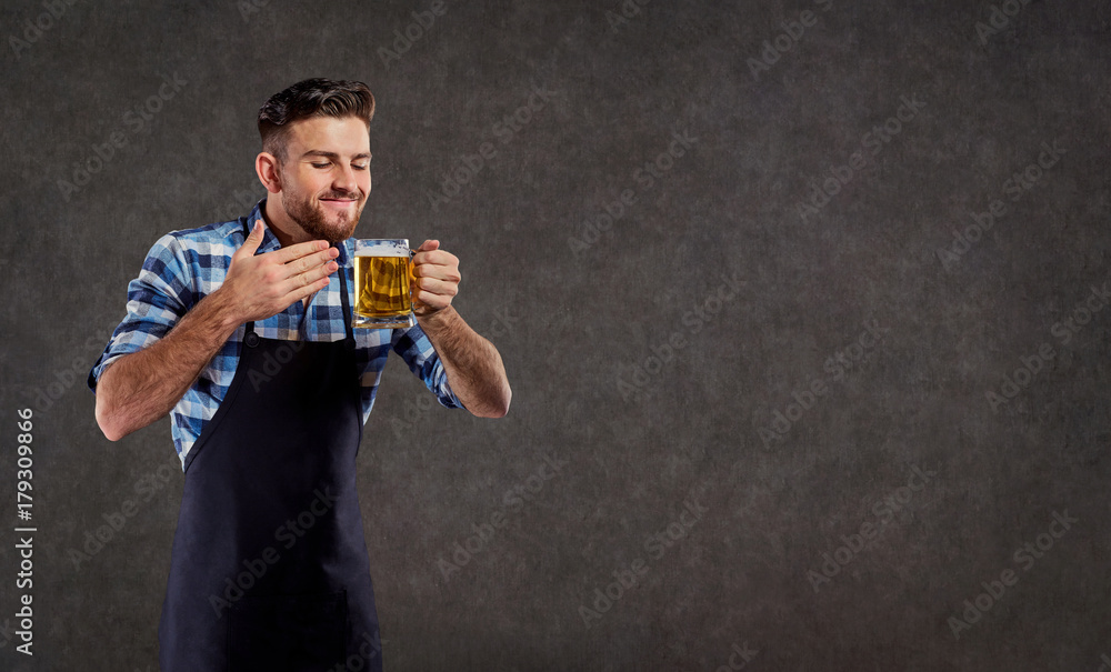 The brewer in his apron sniffs the smell of freshly brewed beer on the ...