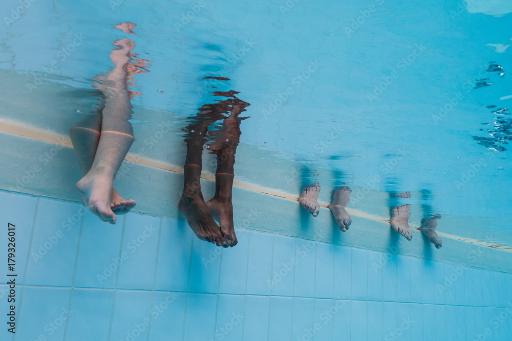Feet of four women underwater in a pool Stock Photo | Adobe Stock