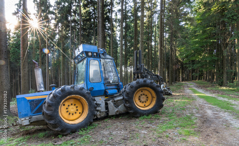 Blue harvester in a sunny summer wood. Industrial background with ...