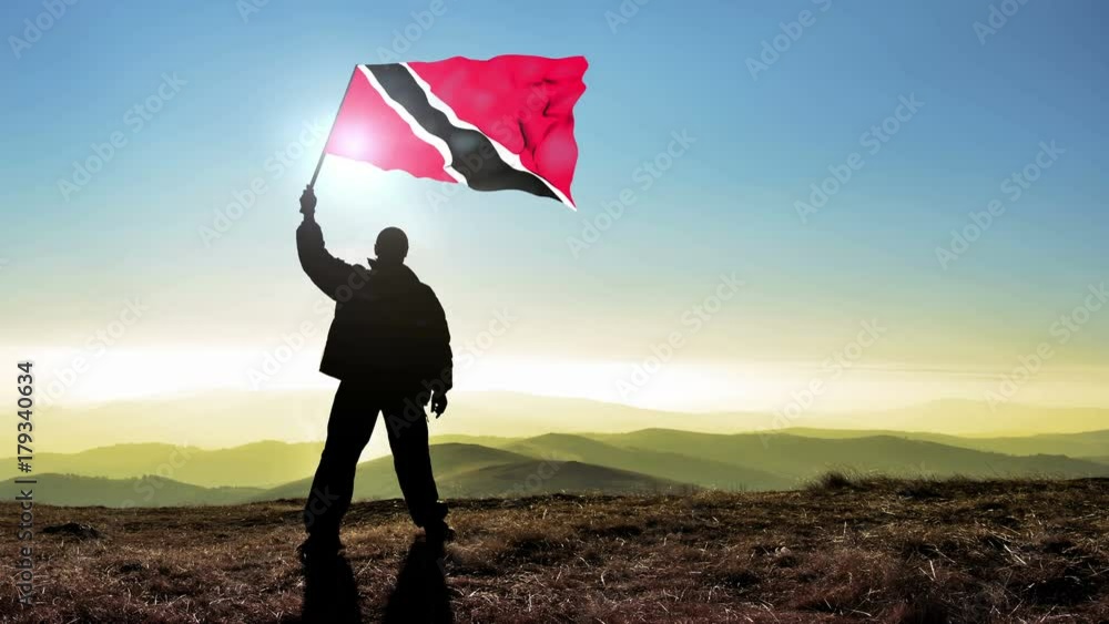 Successful silhouette man winner waving Trinidad and Tobago flag on top ...