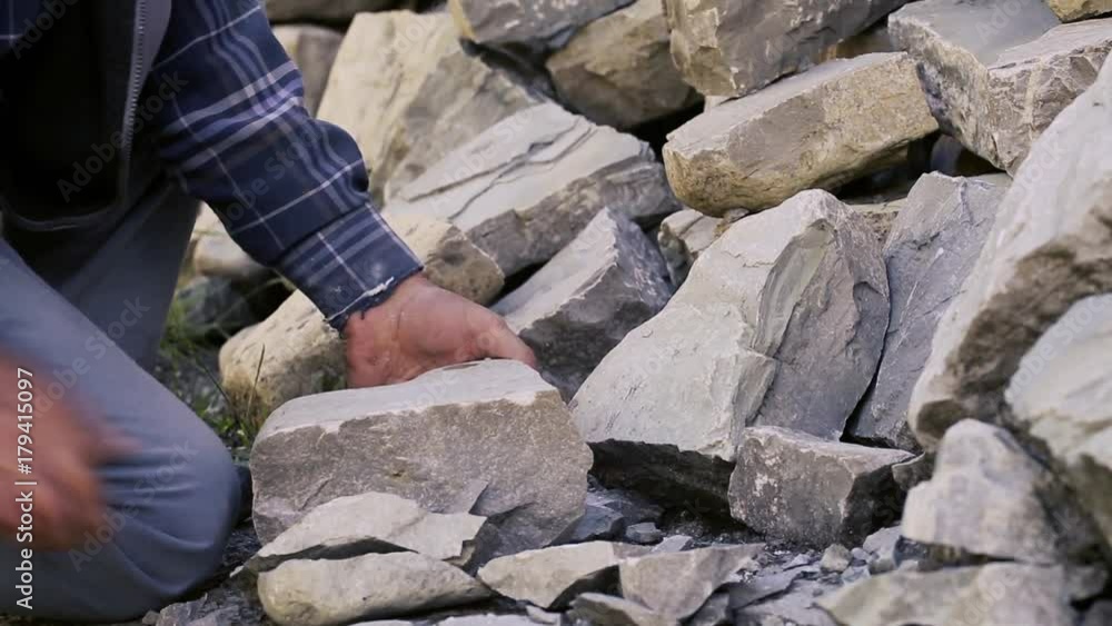 Stonemason cutting a block of granite with sledgehammer. Pitching ...