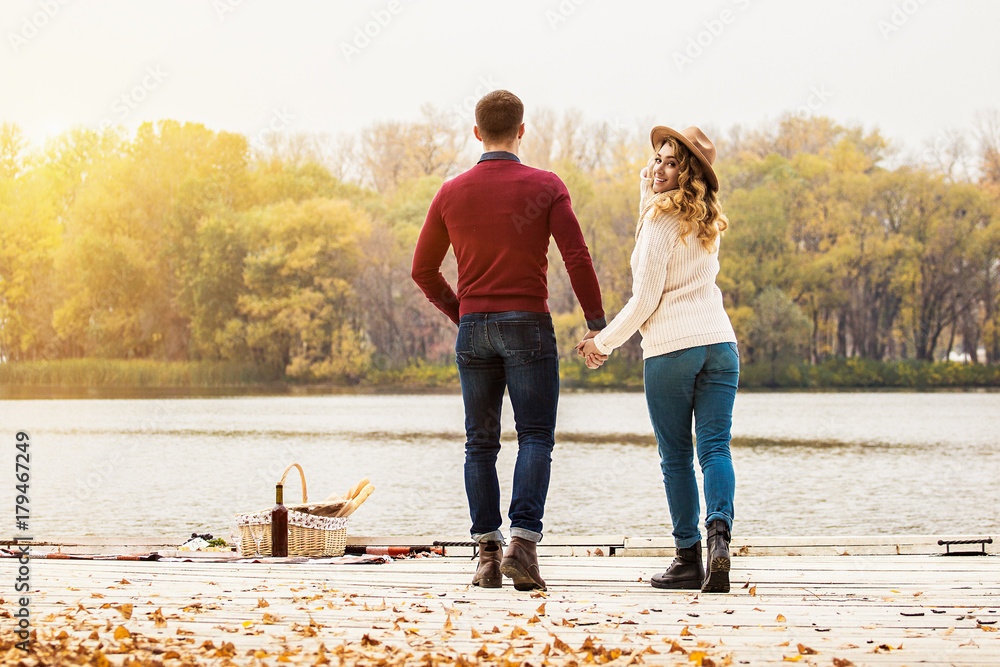 Happy to be together. Horizontal shot of young beautiful couple walking outdoors and holding ...