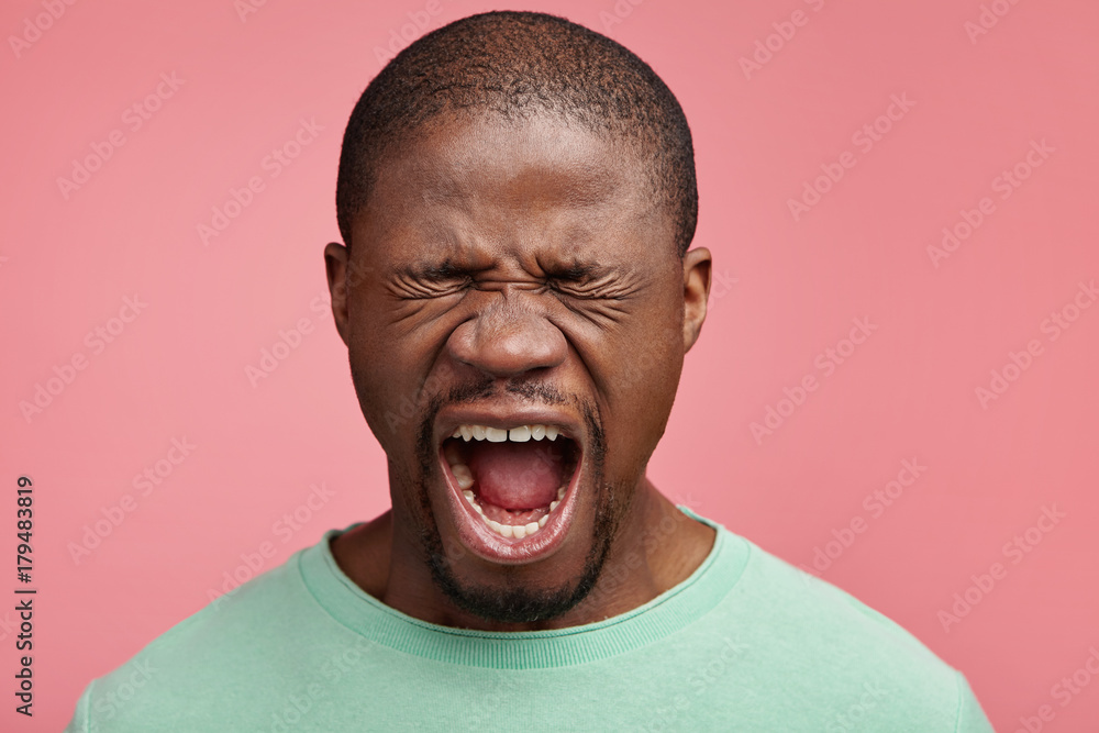 Emotional African American male closes eyes in despair, opens mouth ...