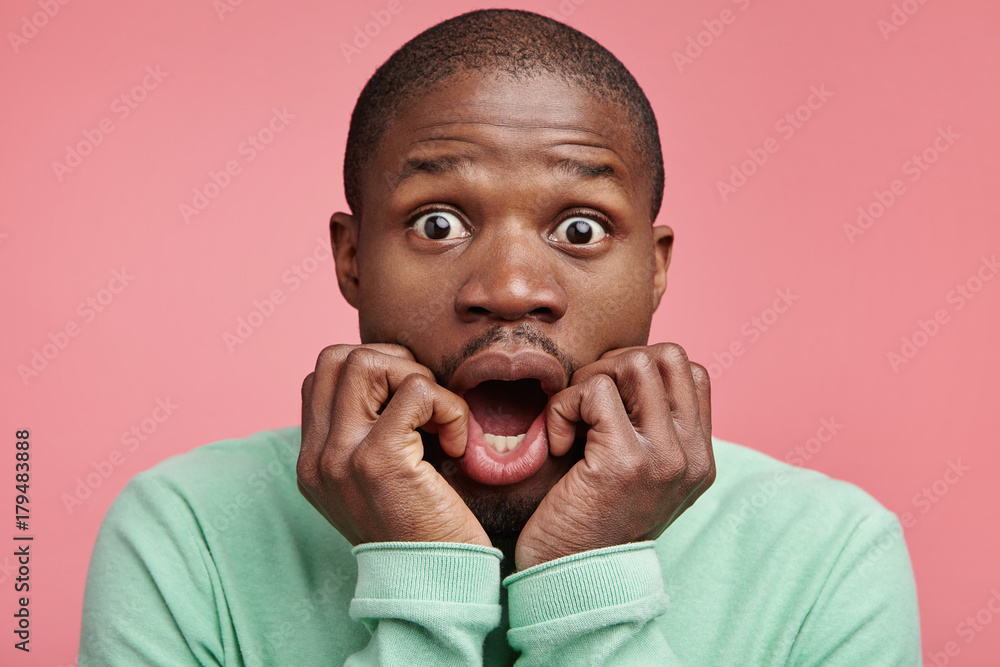 Horizontal portrait of horrified dark skinned young man being ...