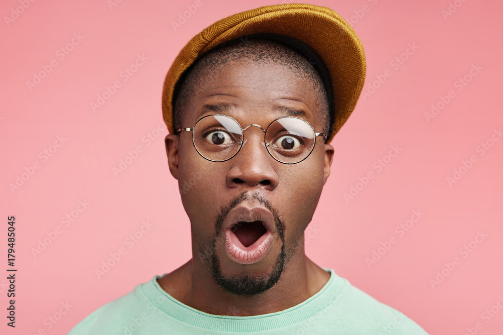 Fashionable black male with specific appearance keeps mouth widely ...