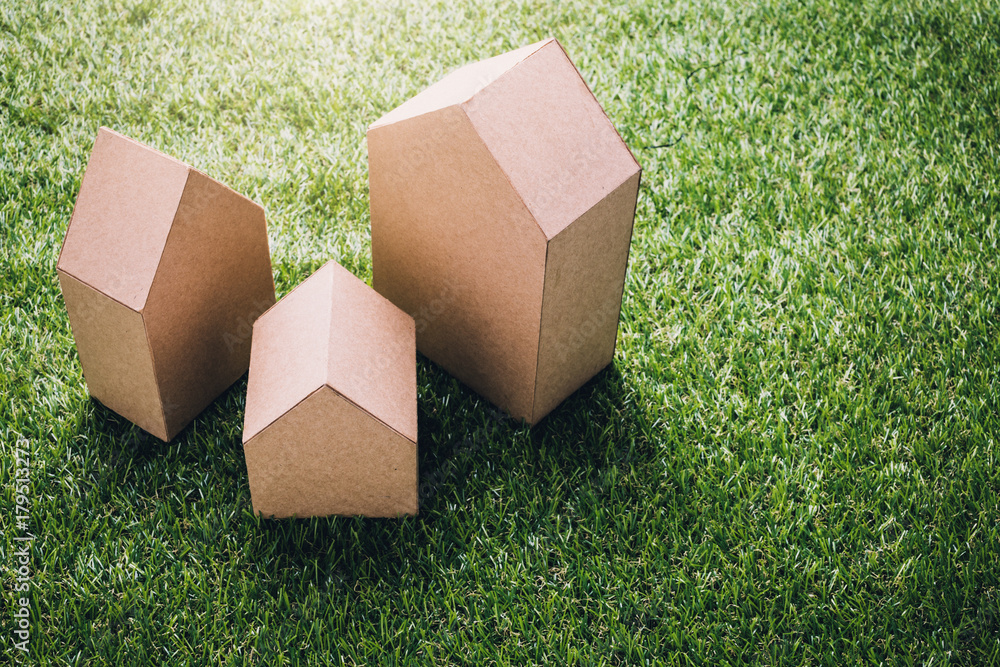 house concept with house paper model with drawing tools on green grass ...