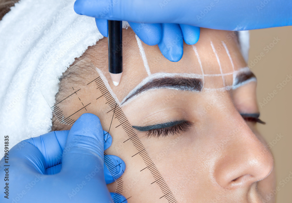 Permanent make-up for eyebrows of beautiful woman with thick brows in ...