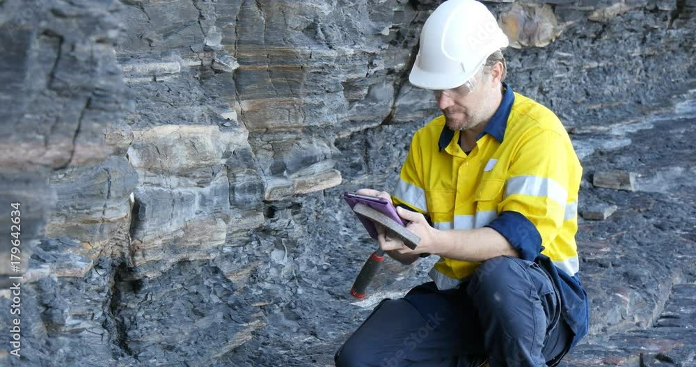Modern data collection Geologist is field taking notes for mineral ...