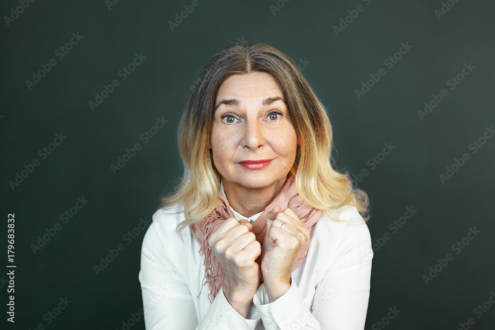 Emotional mature woman raising eyebrows, having fascinated look ...