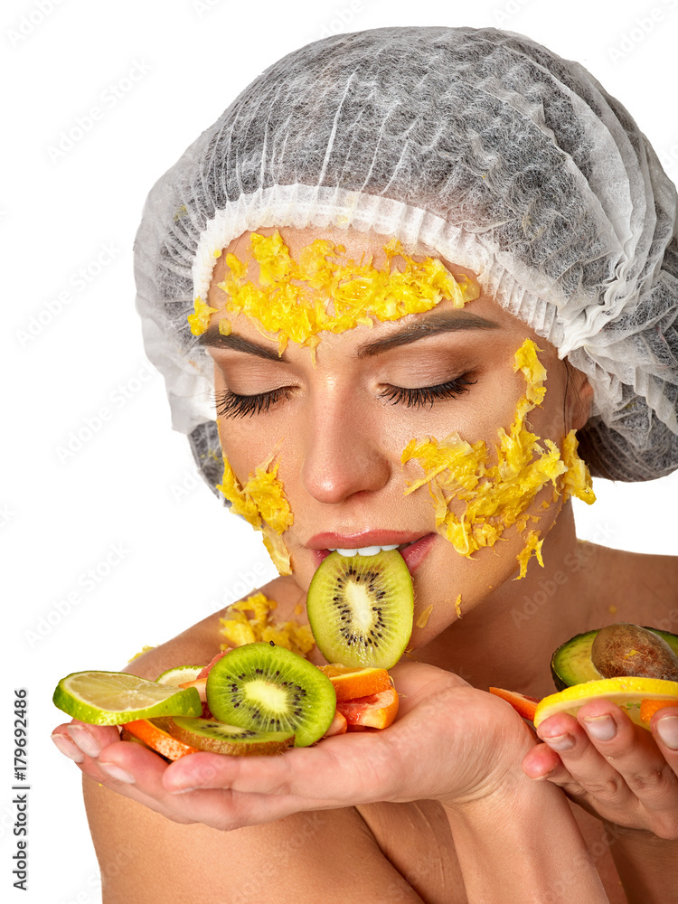 Facial mask from fresh fruits for woman. Girl in medical hat bit slices ...