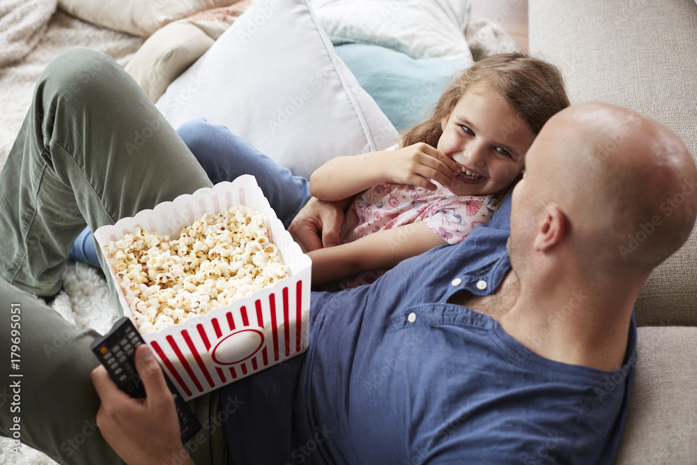 Dad and daughter eating popcorn at home, elevated side view Stock Photo ...