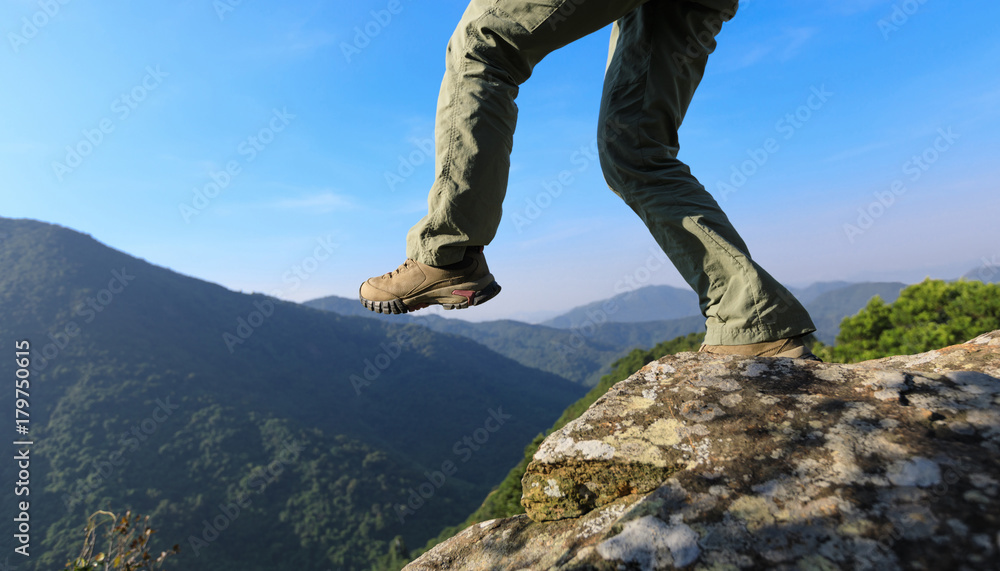 brave woman hiker walking to the cliff edge on top of mountain Stock ...