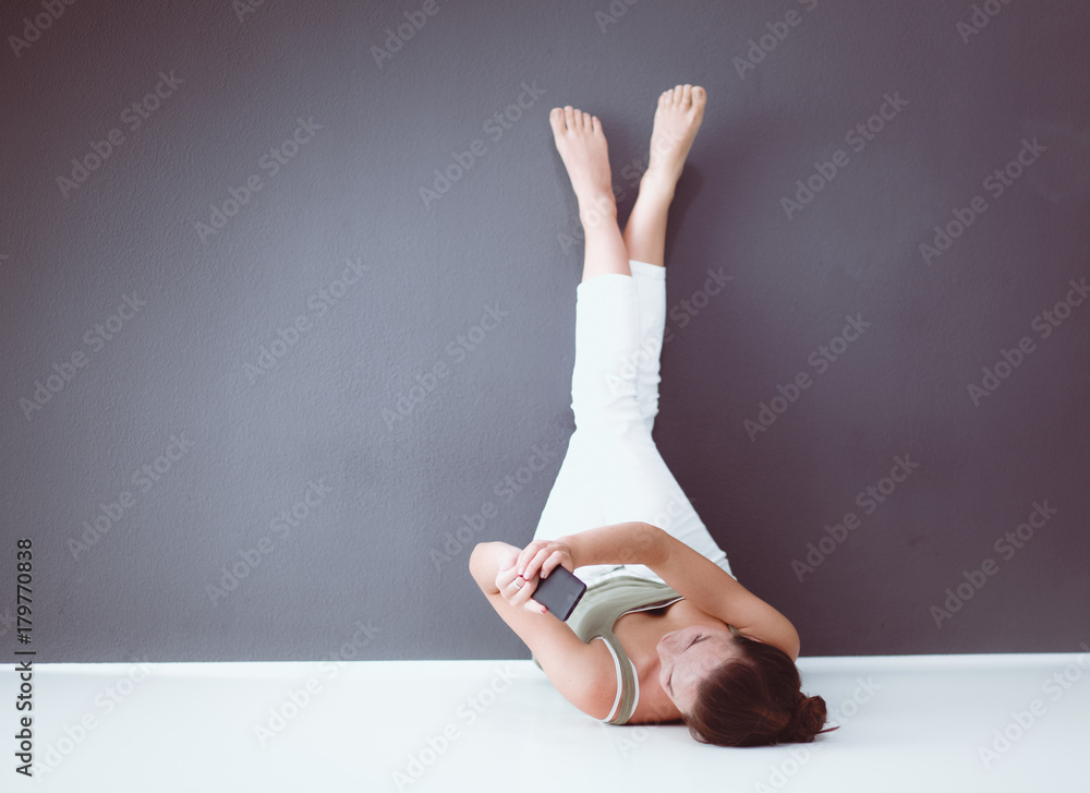 Happy cute woman lying on the floor with legs raised up Stock Photo ...