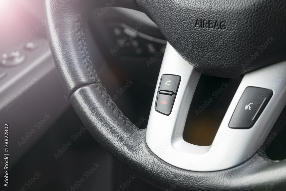 Hands free buttons on the steering wheel in black leather, modern car ...