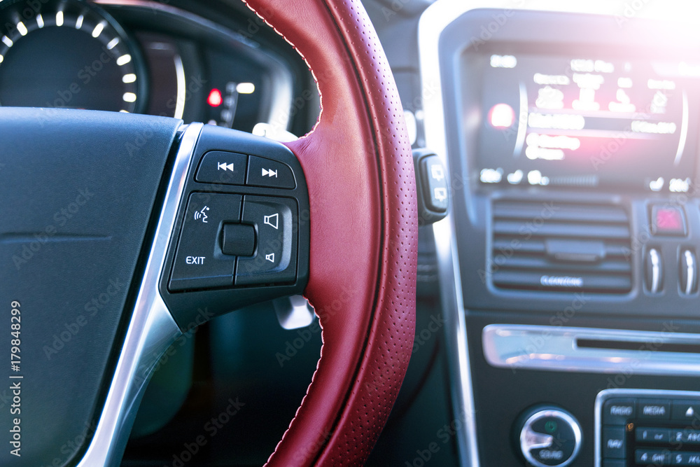 Media control buttons on the red steering wheel in black leather with ...