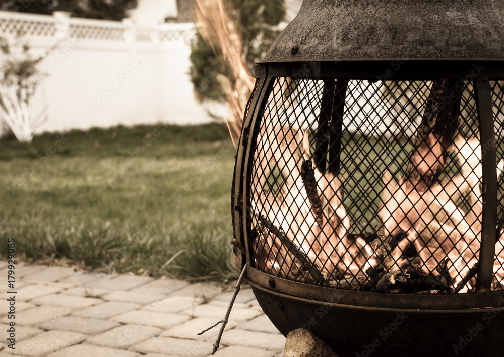 Outdoor fire pit with roaring fire. Chimera in backyard with strong ...