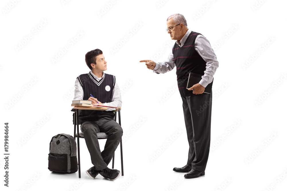 Teacher scolding a teenage student seated in a school chair Stock Photo ...